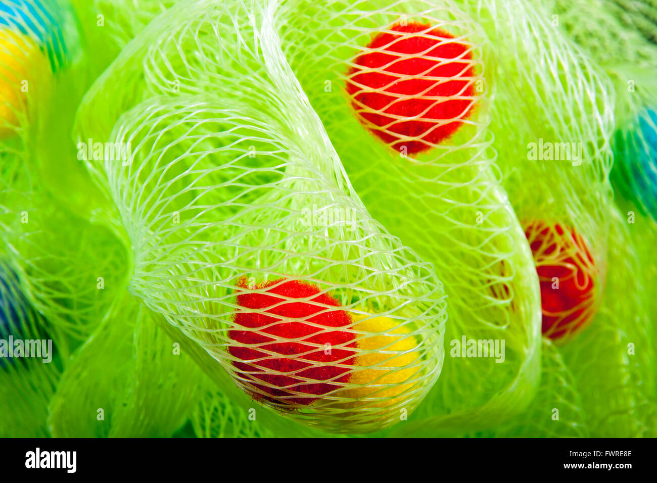 Close up of green mesh bath puff with red and yellow baubles Stock ...