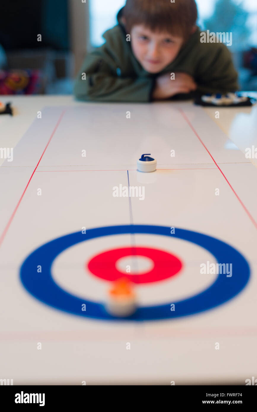 Table curling game being played by child Stock Photo - Alamy