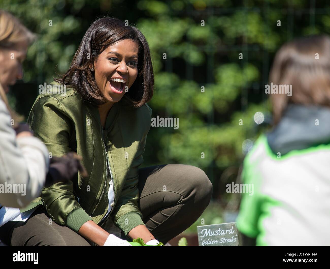 U.S First Lady Michelle Obama laughs while working alongside student ...