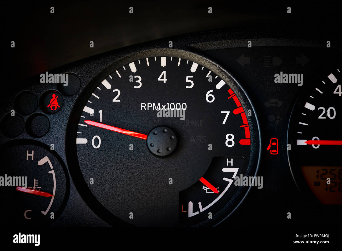 Dashboard of a car showing tachometer, partial speedometer, temerature ...