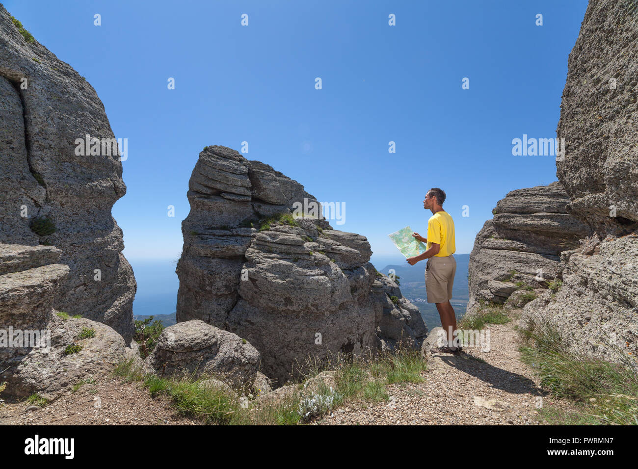 Man walking at the rocks with map Stock Photo - Alamy