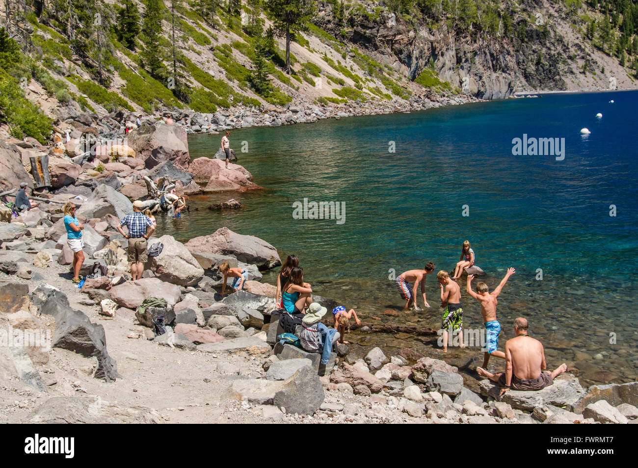 Tourists swimming in the crystal clear water of Crater Lake. Crater ...