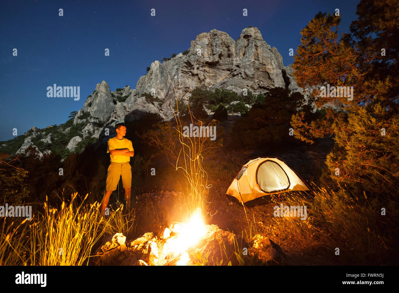 Man tent camping at night with campfire Stock Photo - Alamy