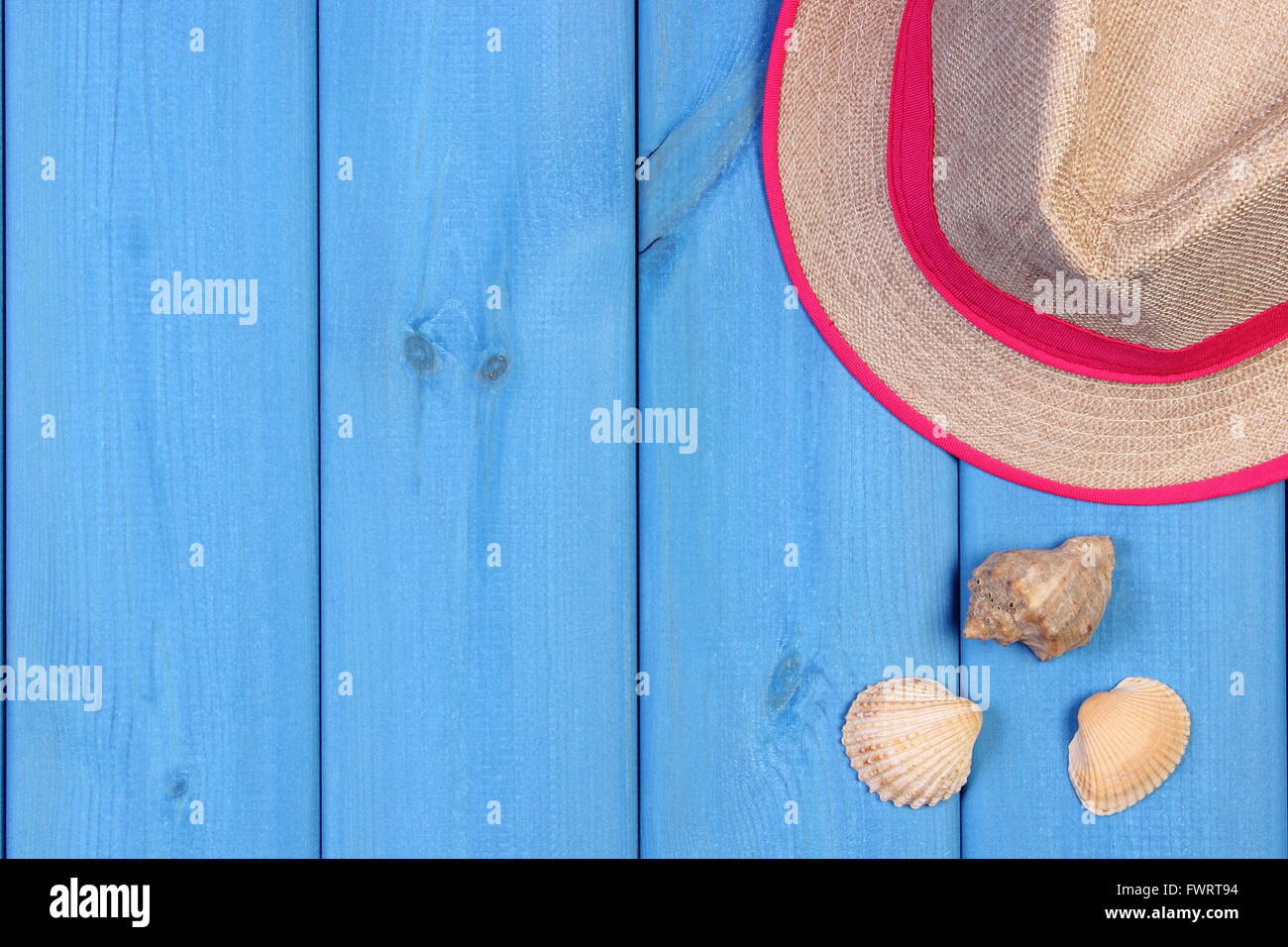 Straw hat with seashells on blue wooden boards, accessories for ...