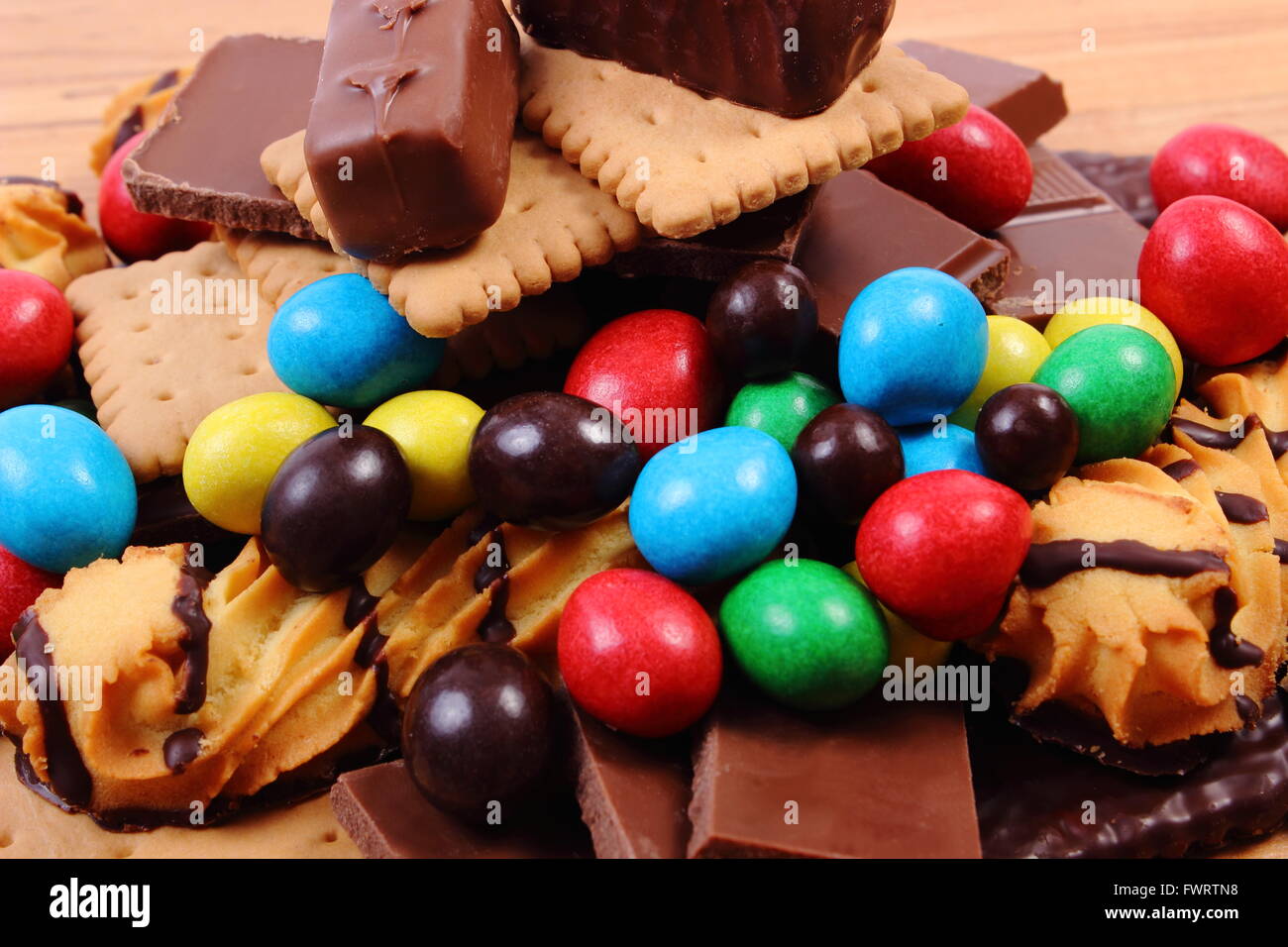 Heap of candies and cookies on wooden table, too many sweets, concept ...