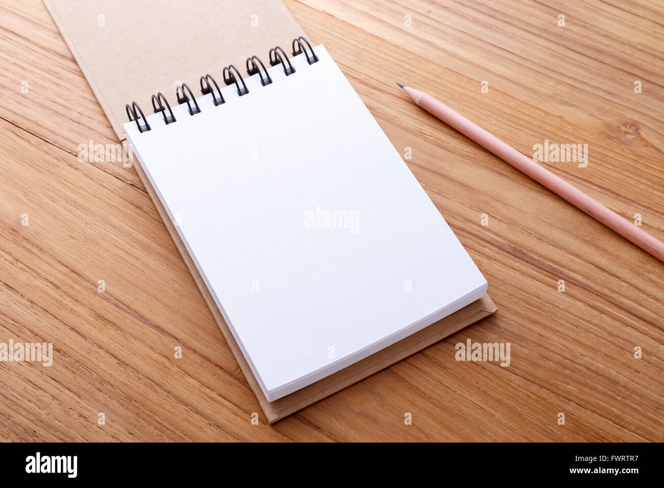 Spiral notebook with pencil on wood table Stock Photo - Alamy