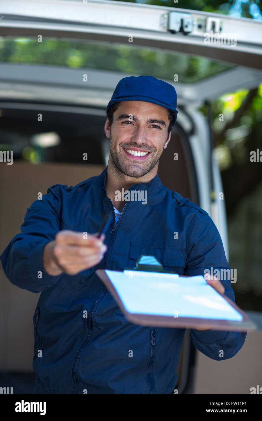 Portrait of delivery person giving clipboard for signature Stock Photo ...