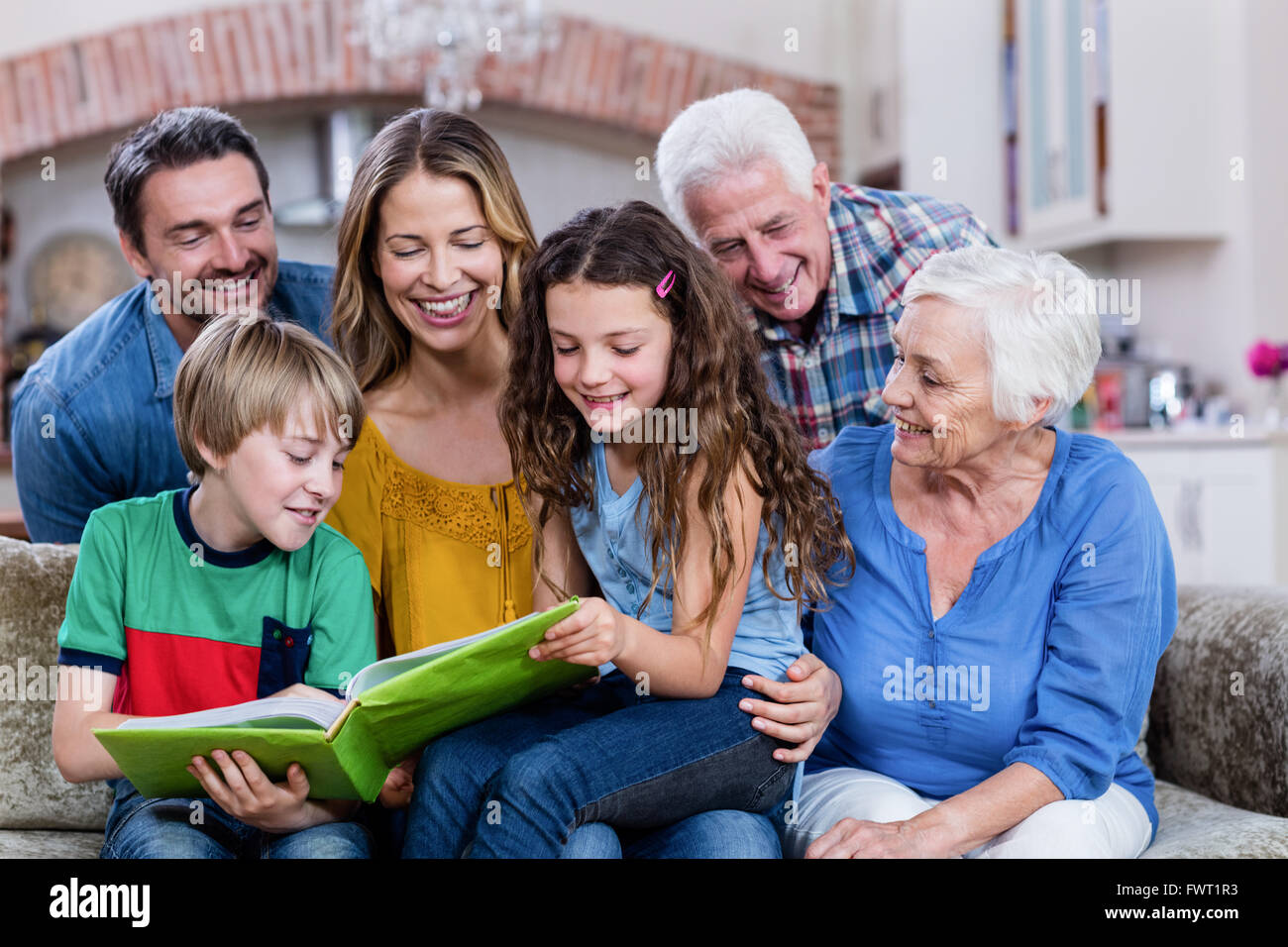 Multi-generation family looking at a photo album Stock Photo - Alamy