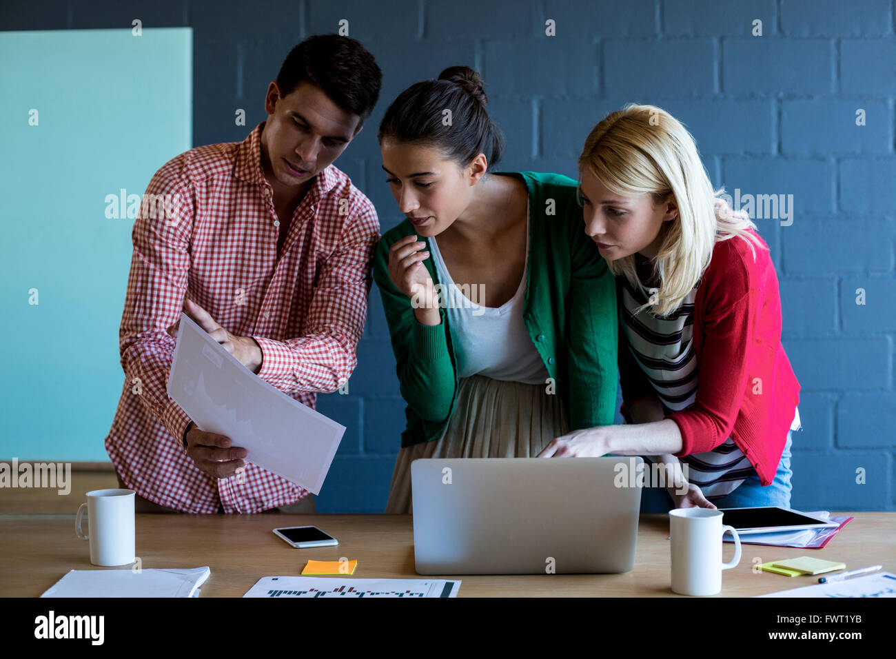 Colleagues discussing at their desk Stock Photo - Alamy