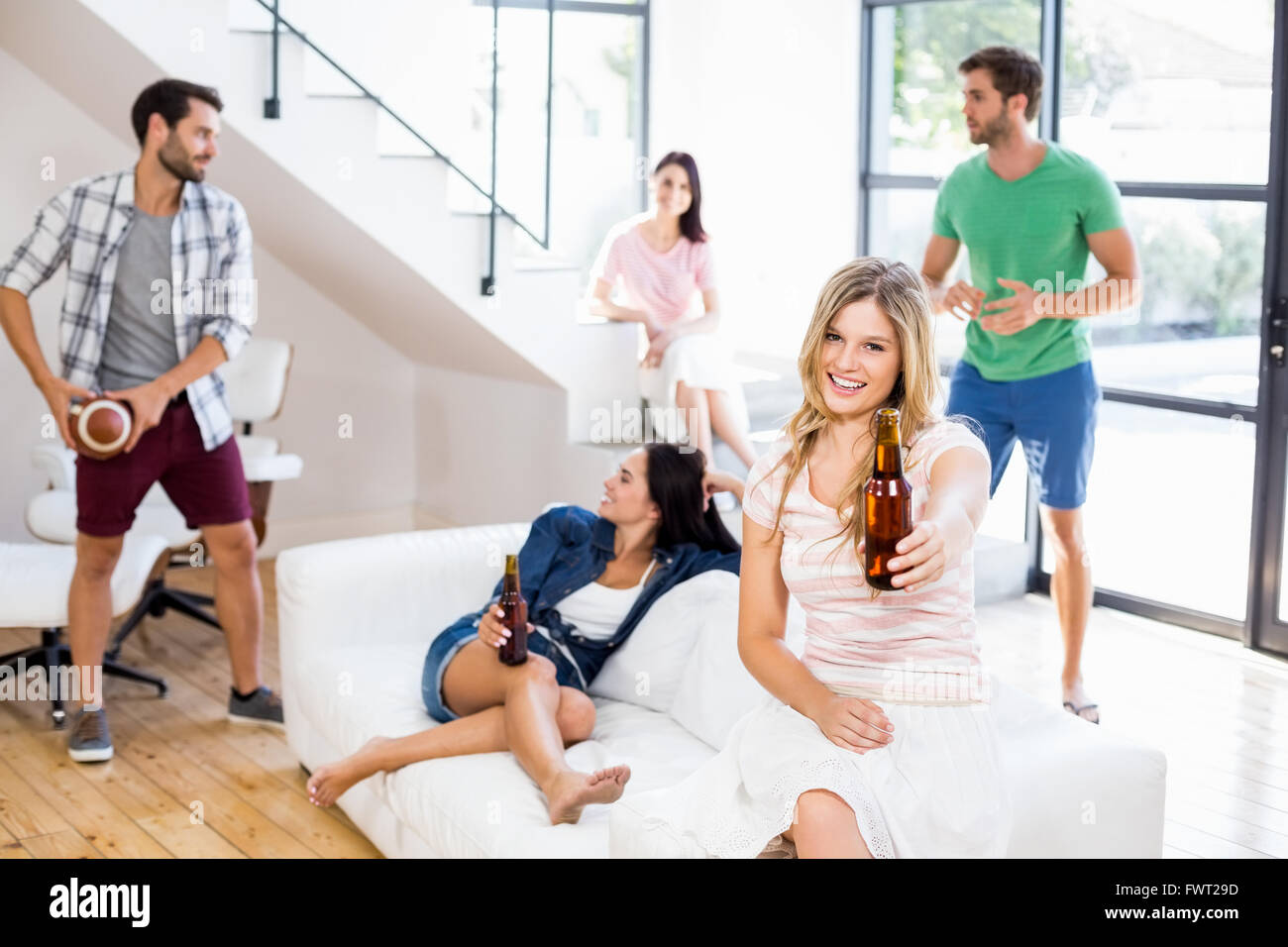 Playful friends having fun and drinking together Stock Photo - Alamy