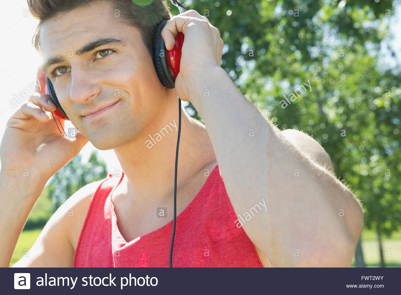 Smiling man listening to music through headphones Stock Photo - Alamy