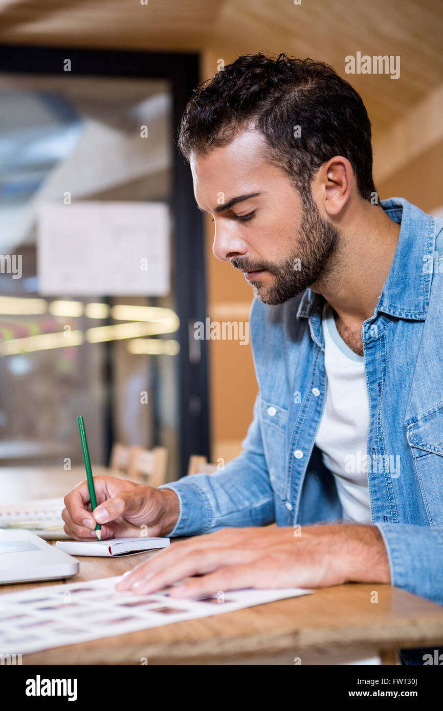 Man in office writing in a notepad Stock Photo - Alamy