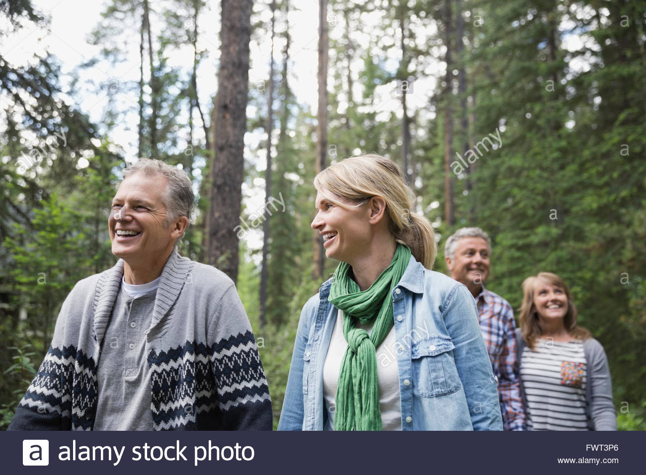 Middle-aged friends walking through the forest Stock Photo - Alamy