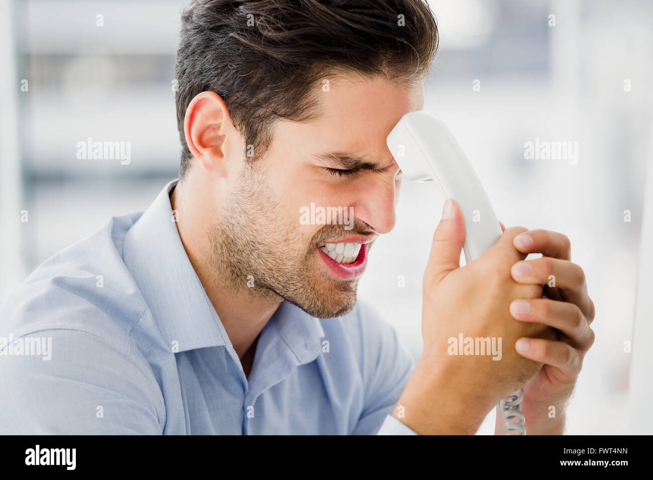 Frustrated businessman holding a telephone Stock Photo - Alamy