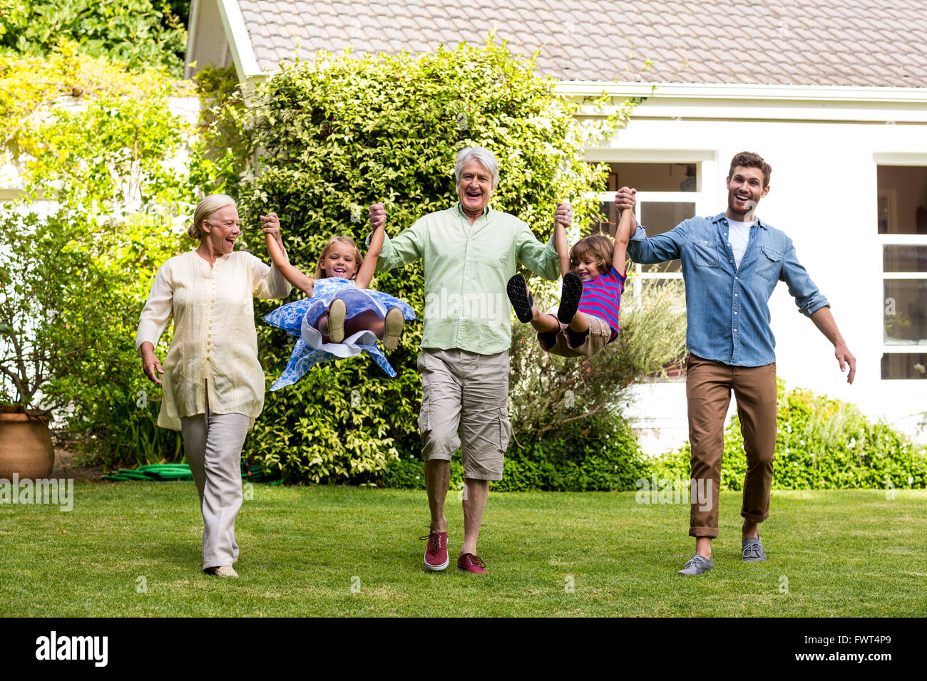 Happy family playing in yard Stock Photo - Alamy