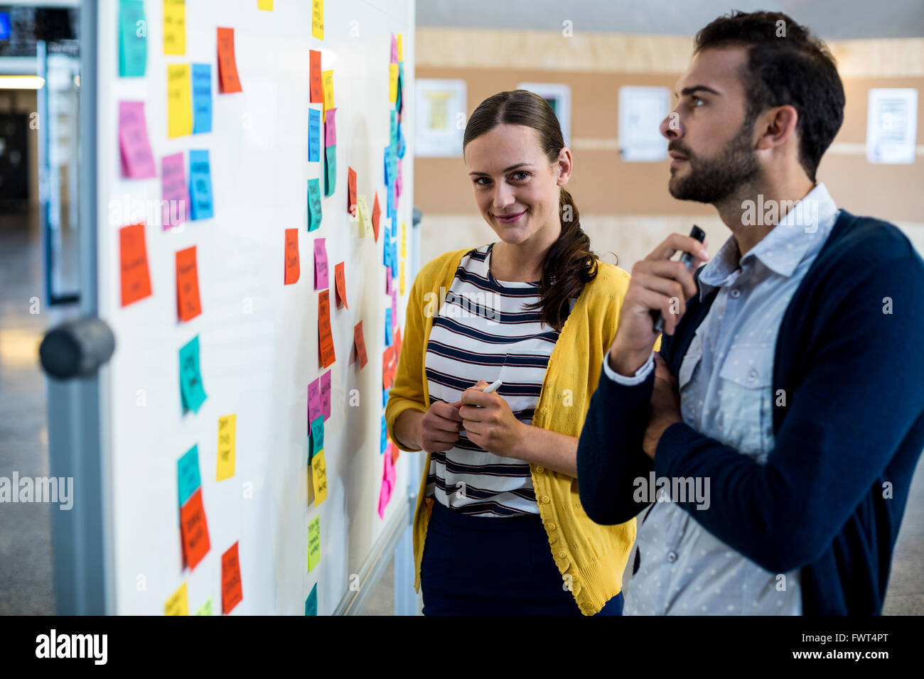 Colleagues looking at white board Stock Photo - Alamy