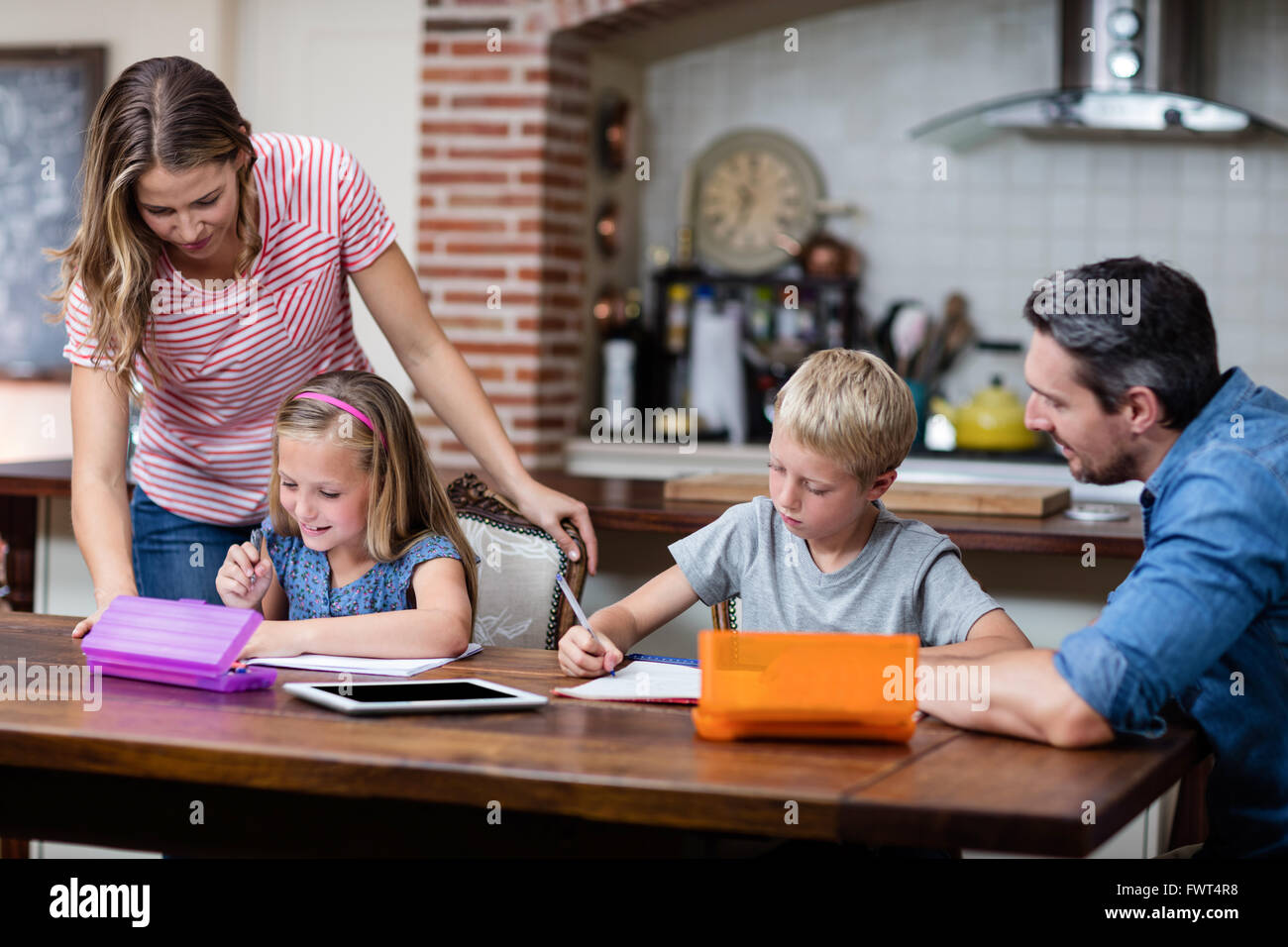 Parents helping the kids with their homework Stock Photo - Alamy