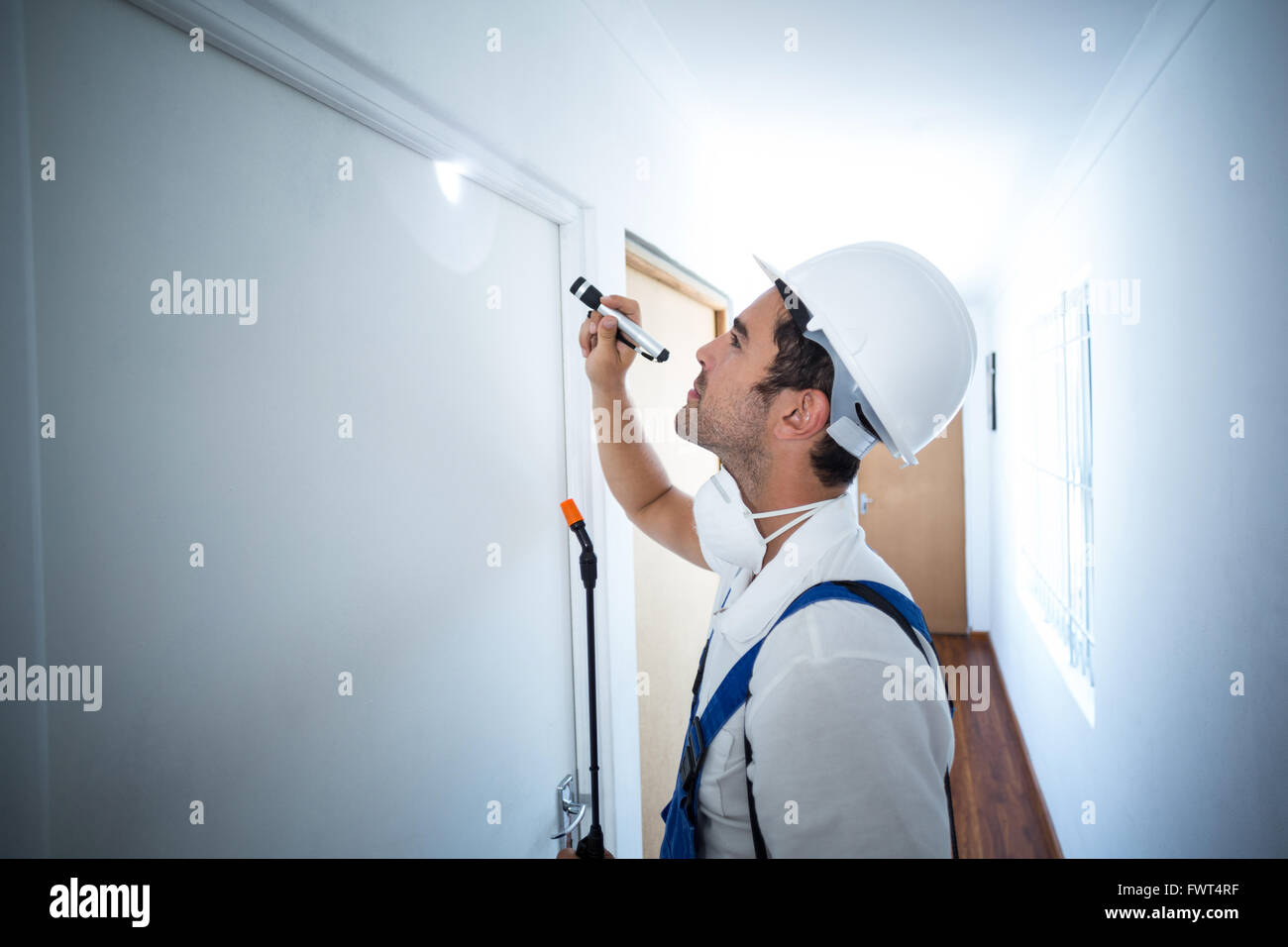 Side view of worker using flashlight in hallway Stock Photo - Alamy