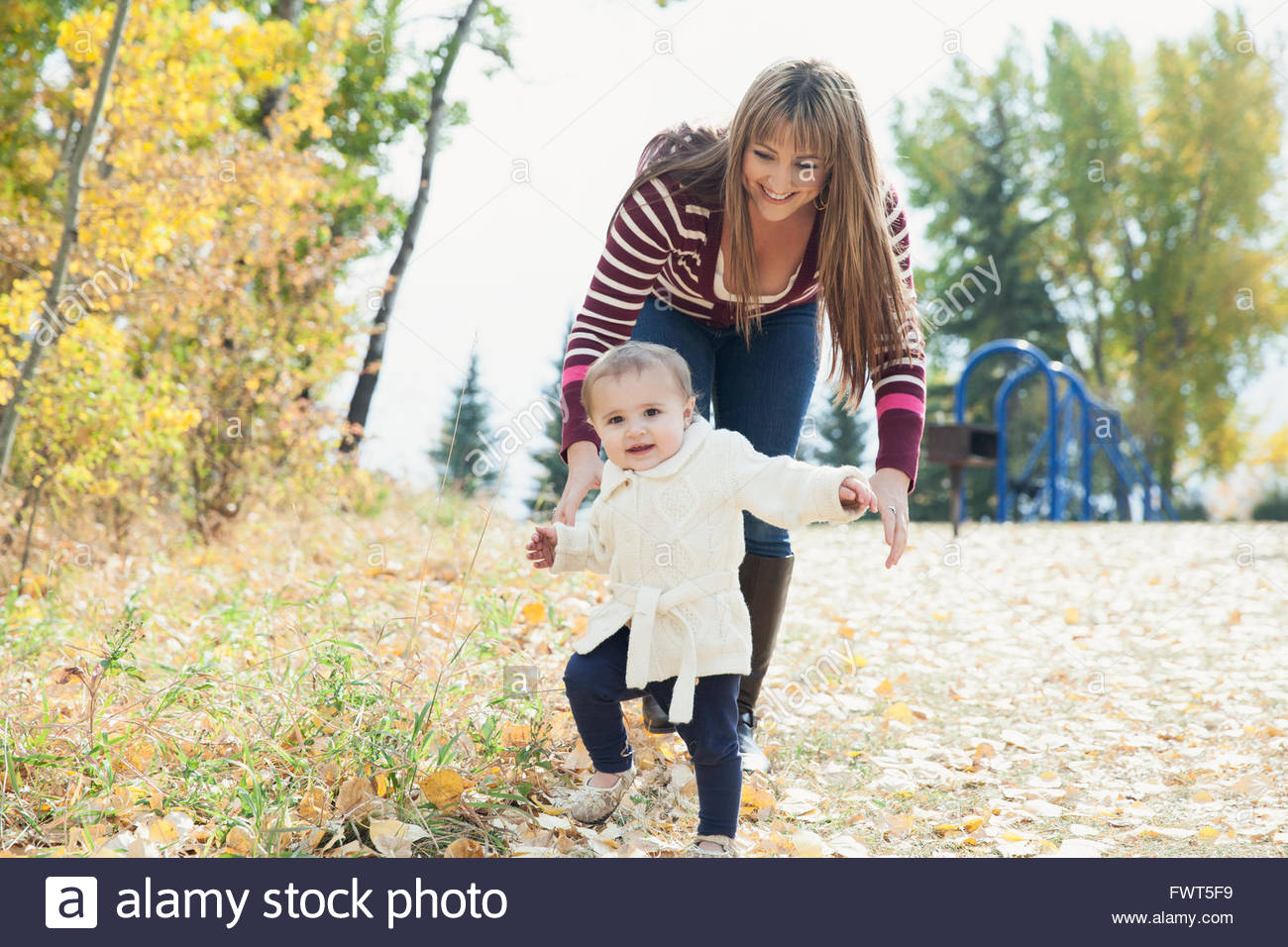 Family helping baby daughter walk hi-res stock photography and images ...