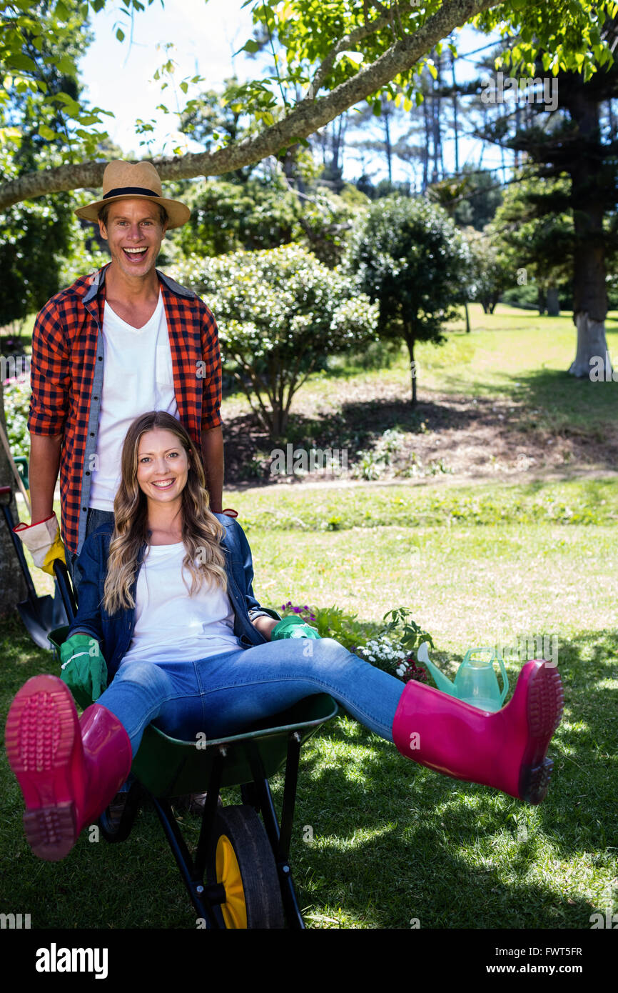 Happy couple playing with a wheelbarrow Stock Photo - Alamy