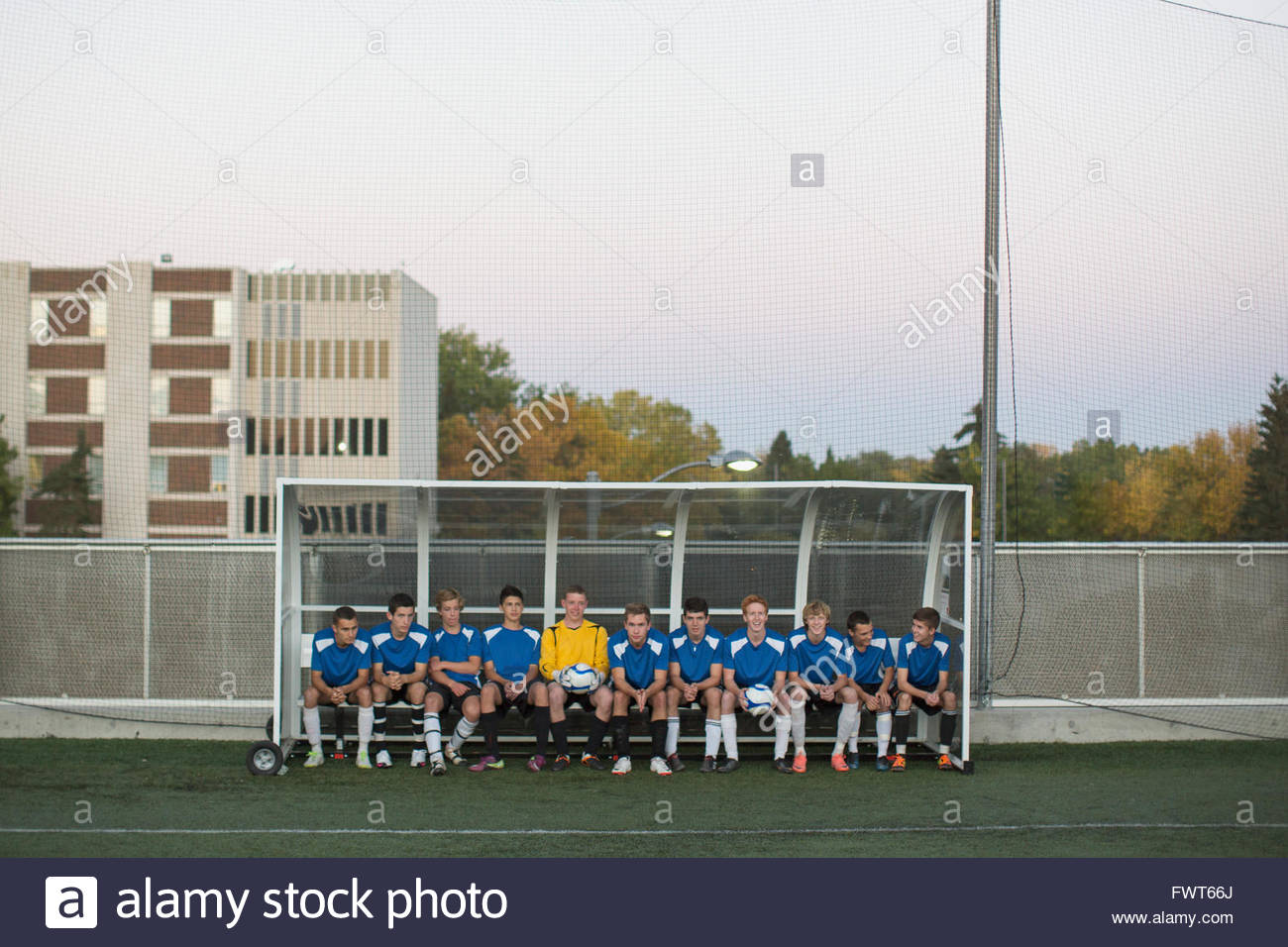 Soccer team sitting on bench together Stock Photo - Alamy