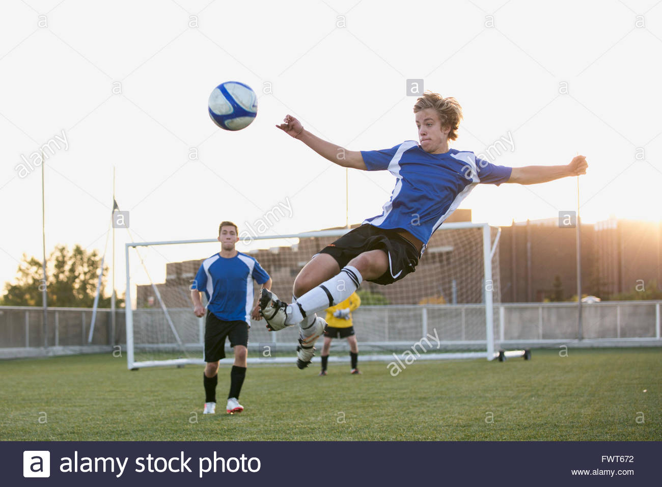 Soccer player in mid-air kicking ball Stock Photo - Alamy