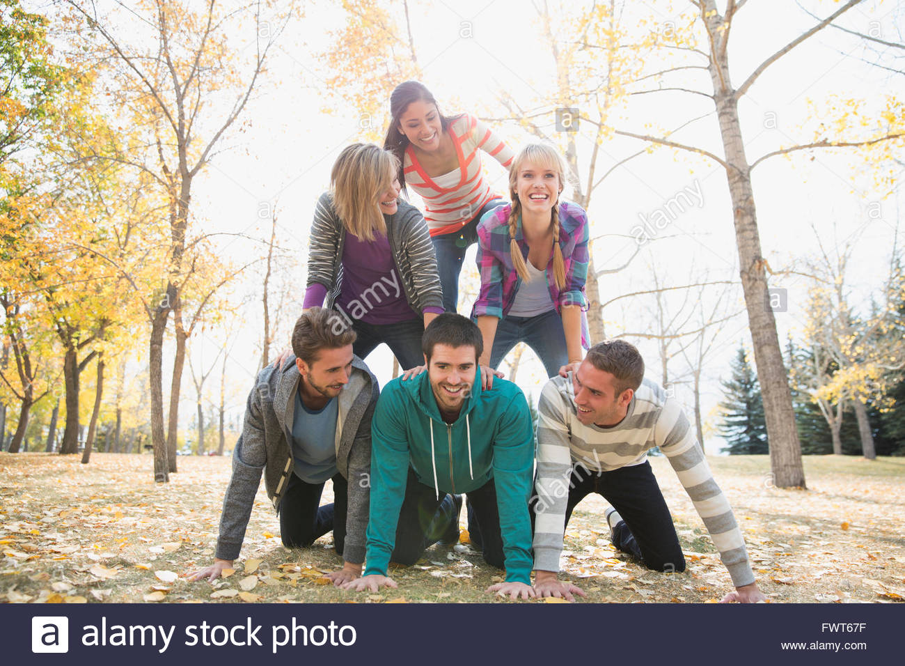 Friends forming a human pyramid in park Stock Photo - Alamy