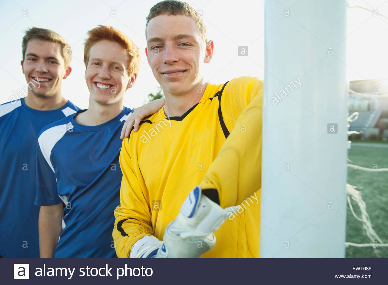 Three teenage soccer players standing together Stock Photo - Alamy