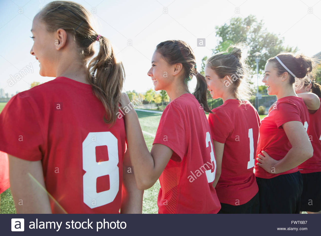 Soccer players watching soccer game from sideline Stock Photo - Alamy