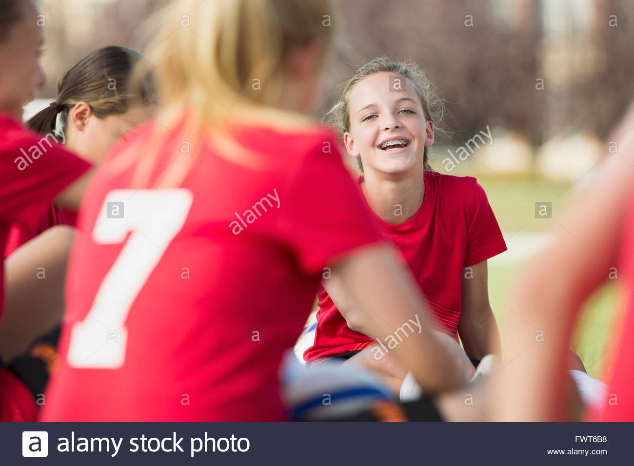 Girls soccer team sitting together on field Stock Photo - Alamy