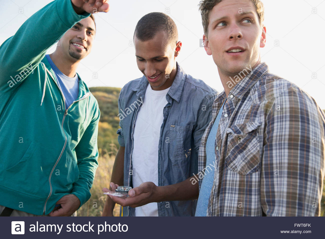 Three men using compass to determine direction Stock Photo - Alamy