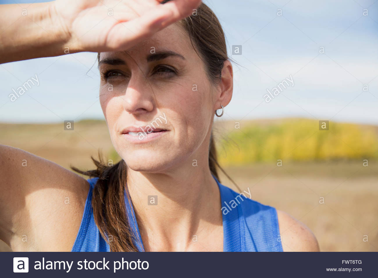 Woman shading her eyes from the sun Stock Photo - Alamy