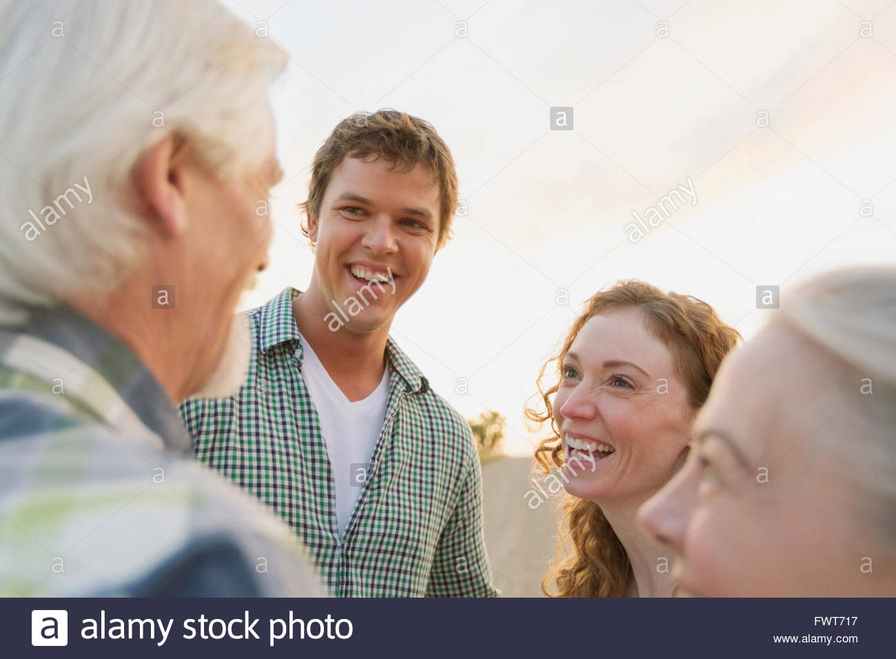 Couple having conversation with adult children outdoors Stock Photo - Alamy