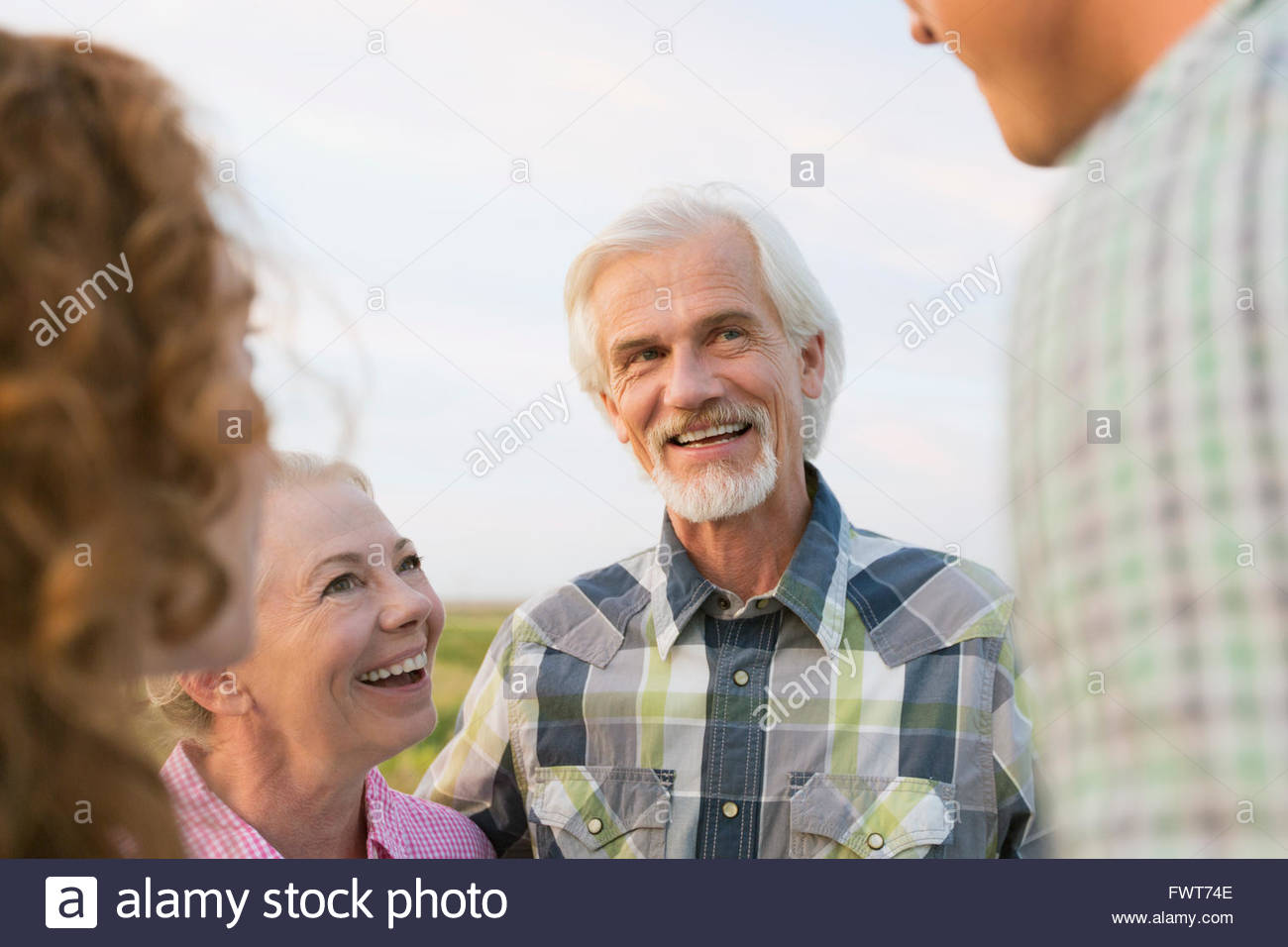 Couple having conversation with adult children outdoors Stock Photo - Alamy