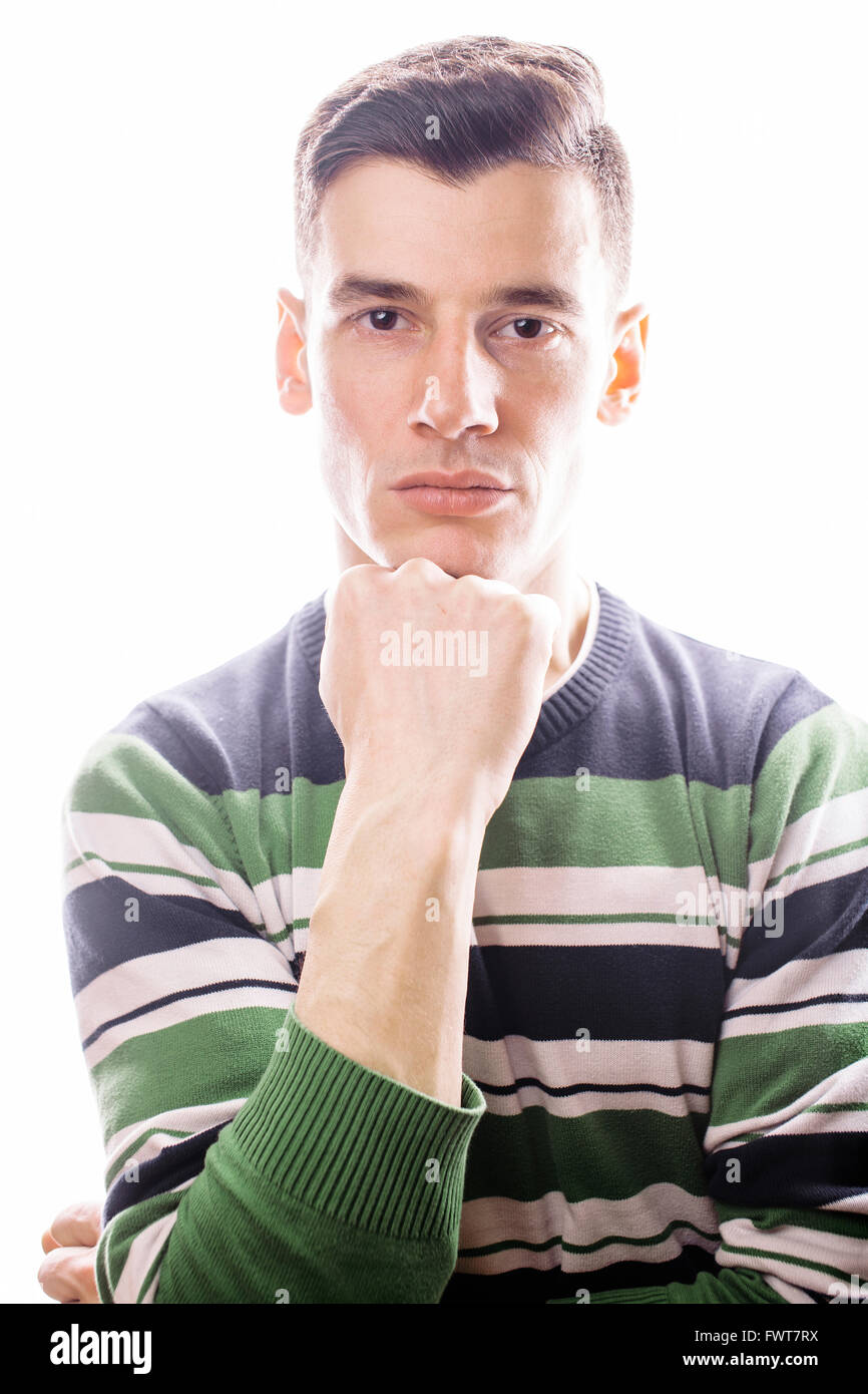 Portrait of a smart serious young man standing against white background ...