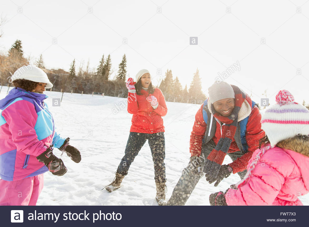 Happy family having a snow ball fight Stock Photo - Alamy