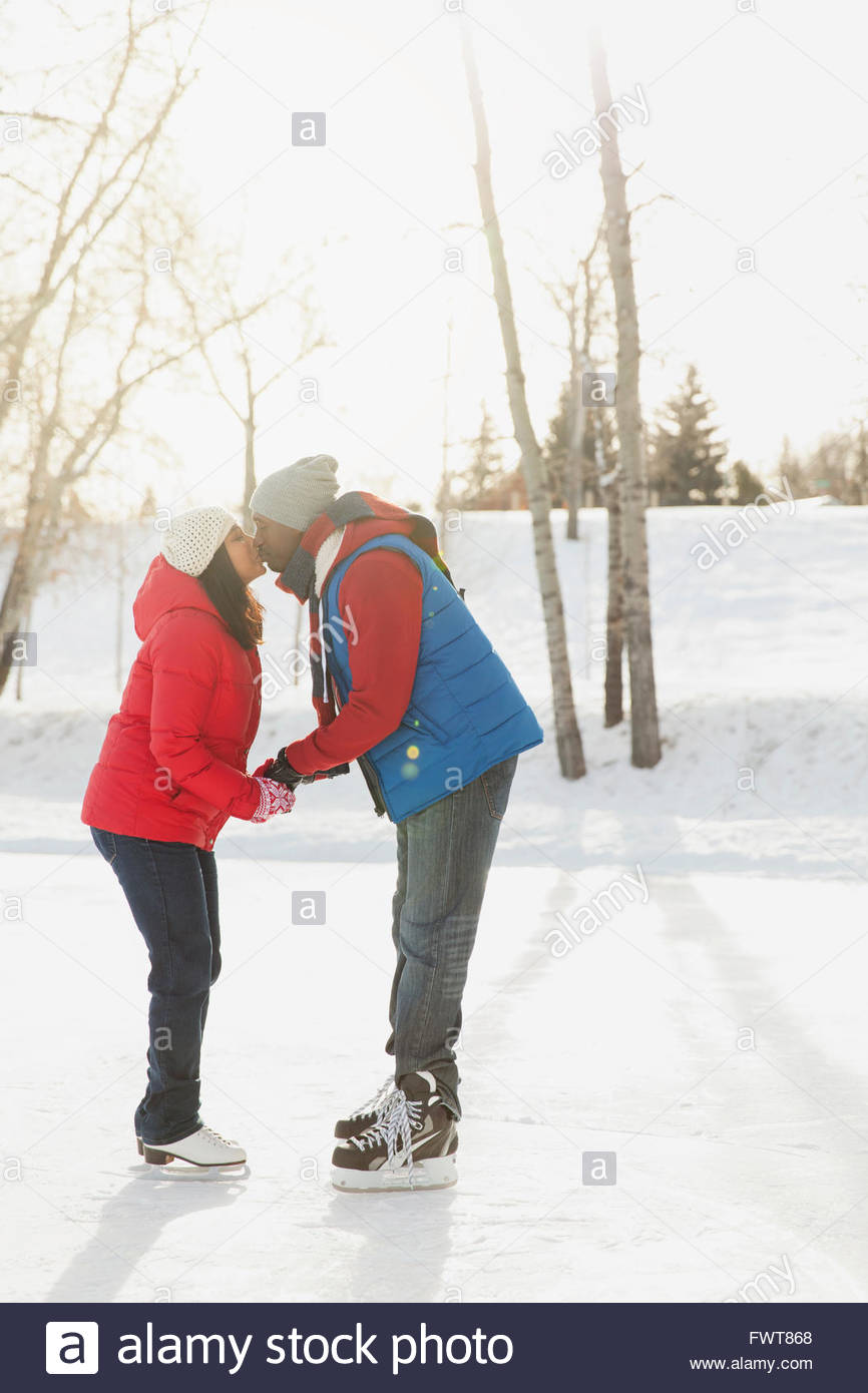Profile shot of romantic couple kissing in snow Stock Photo - Alamy
