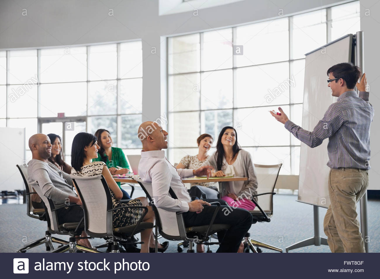 Businessman giving presentation to colleagues in conference room Stock ...