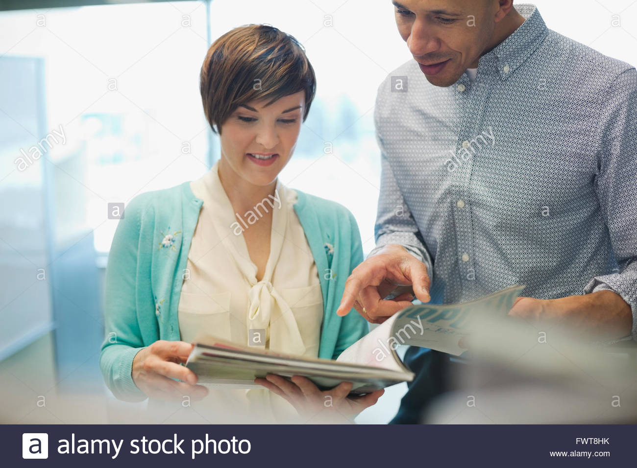 Business coworkers reviewing paperwork together Stock Photo - Alamy