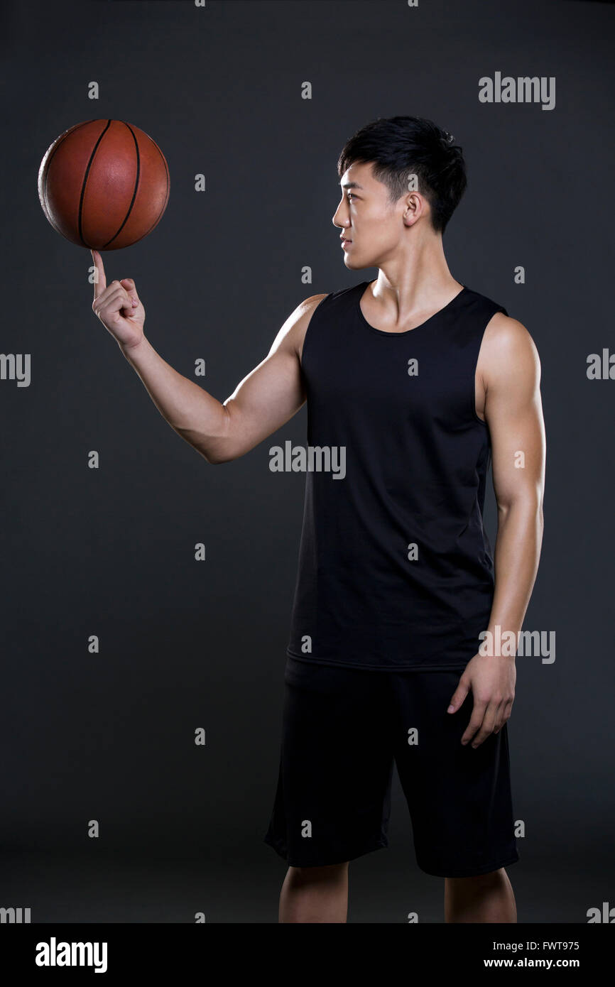 Young man spinning basketball on finger Stock Photo - Alamy
