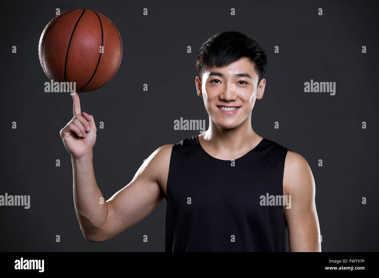 Young man spinning basketball on finger Stock Photo - Alamy