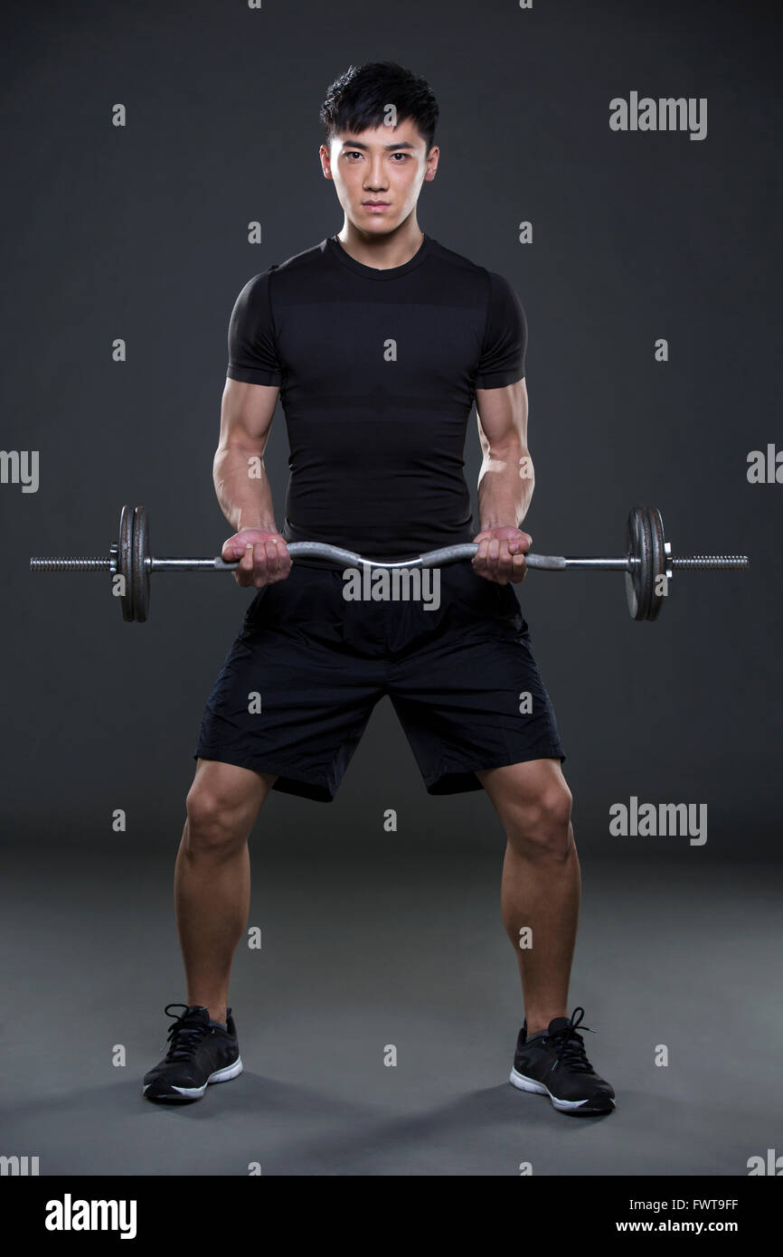 Young man lifting weights Stock Photo - Alamy