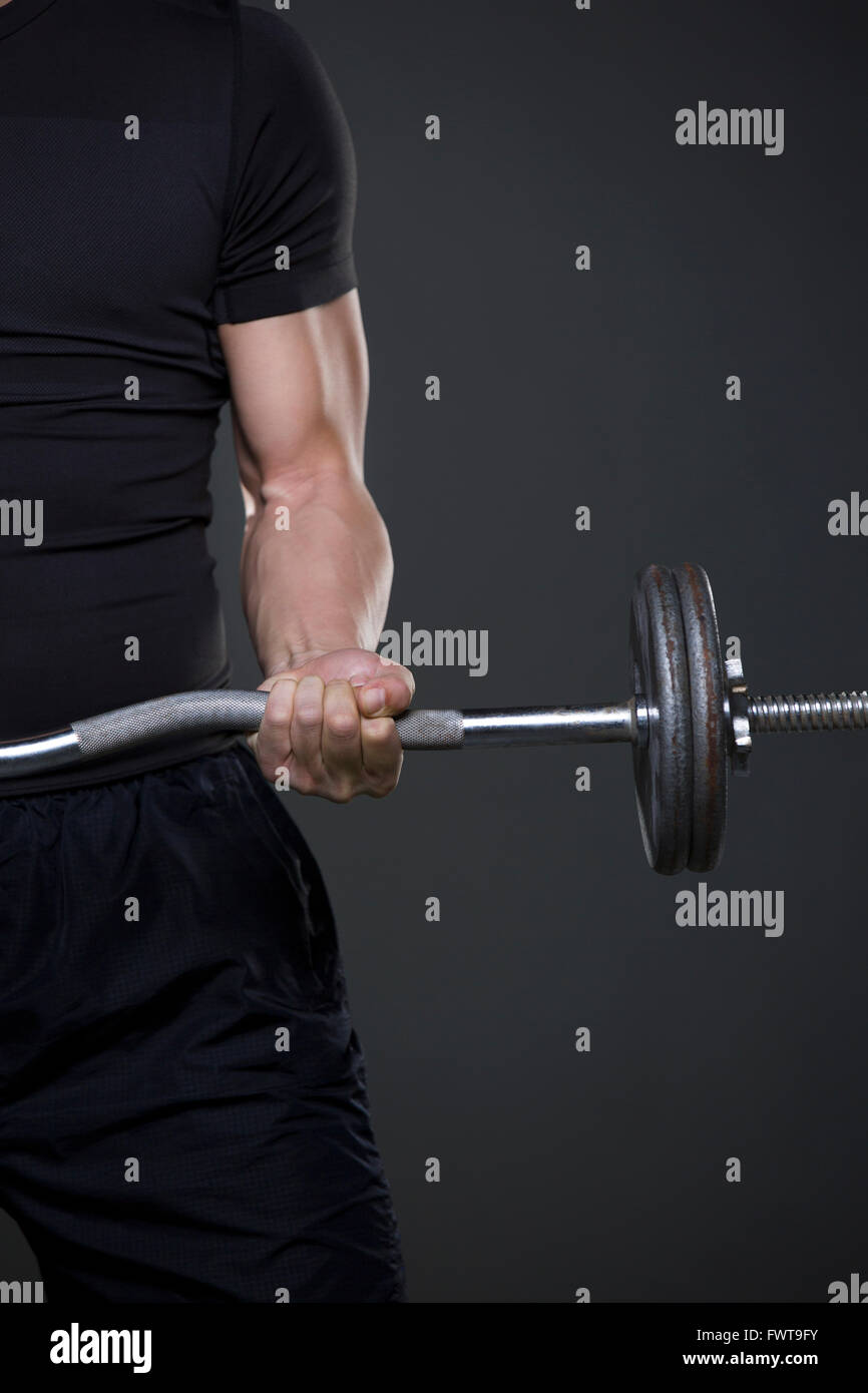 Young man lifting weights Stock Photo - Alamy