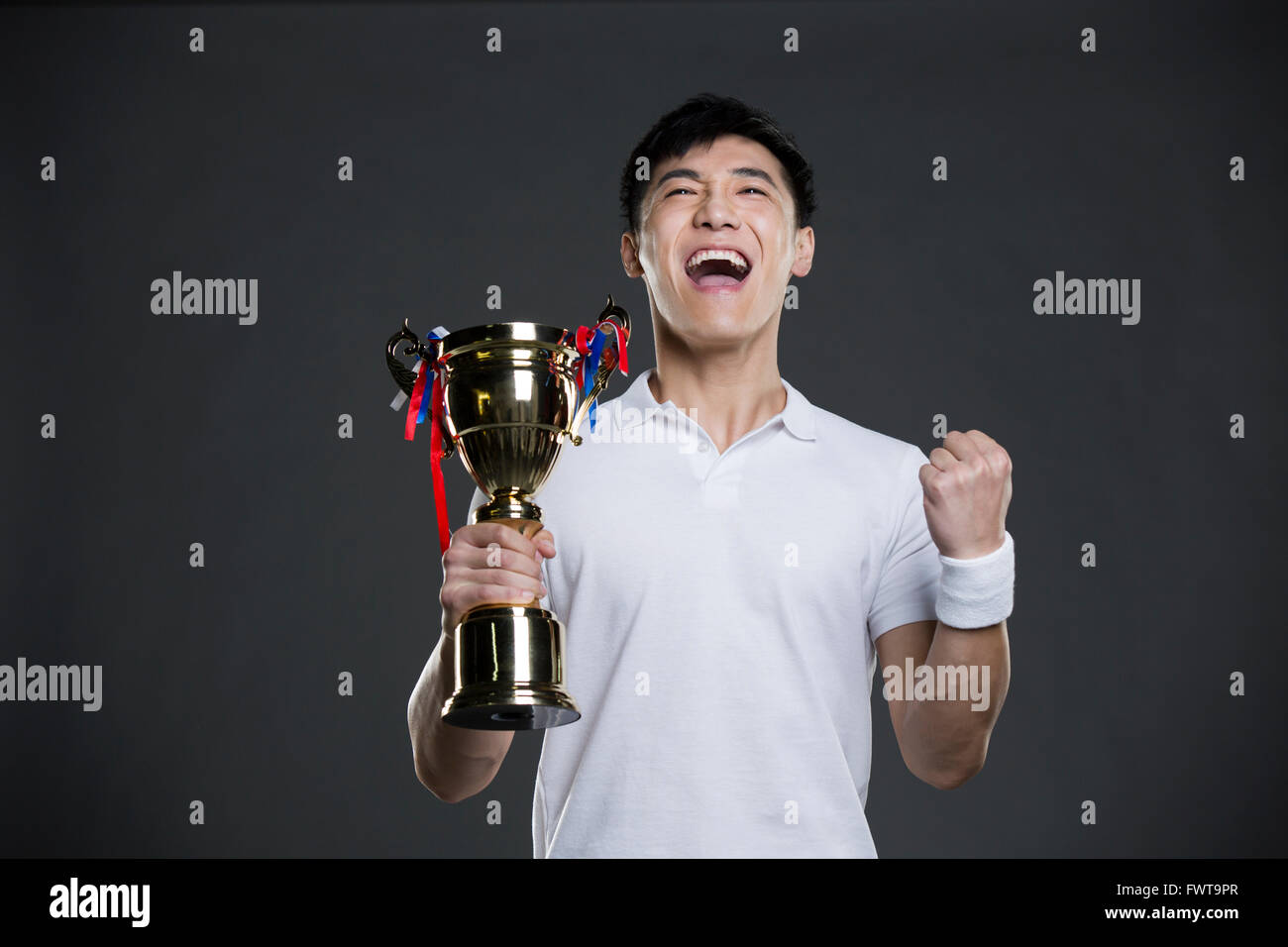 Young man cheering with a trophy Stock Photo - Alamy