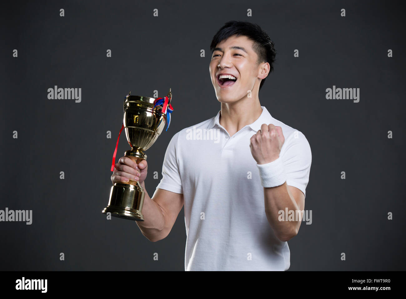 Young man cheering with a trophy Stock Photo - Alamy