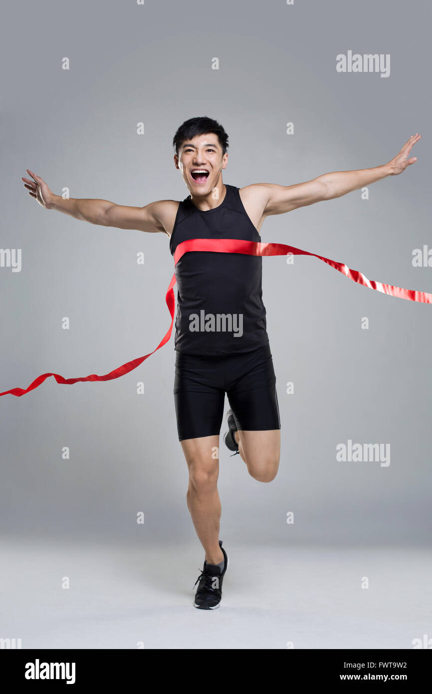 Male athlete running and cheering Stock Photo - Alamy