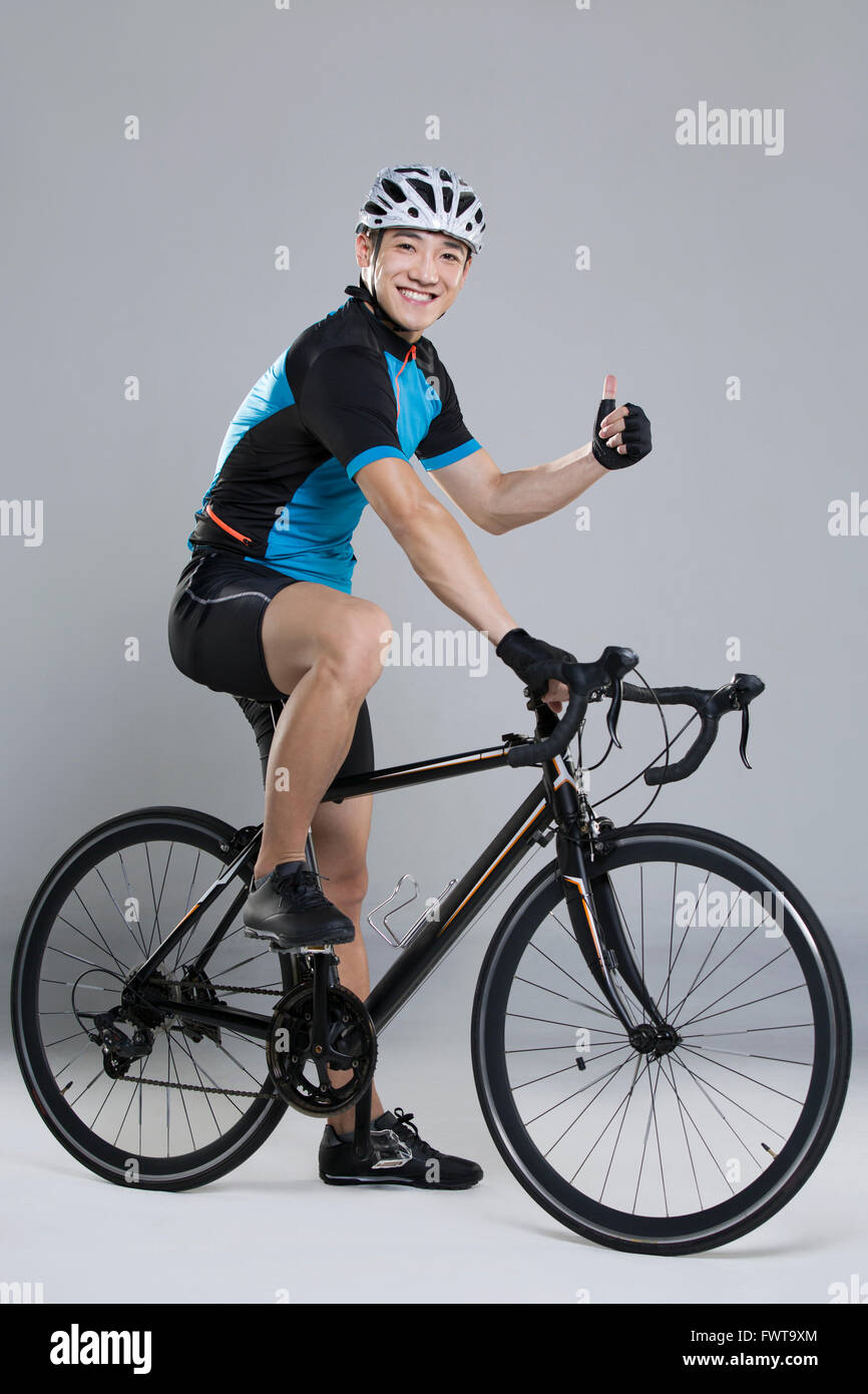 Young man riding bicycle Stock Photo - Alamy