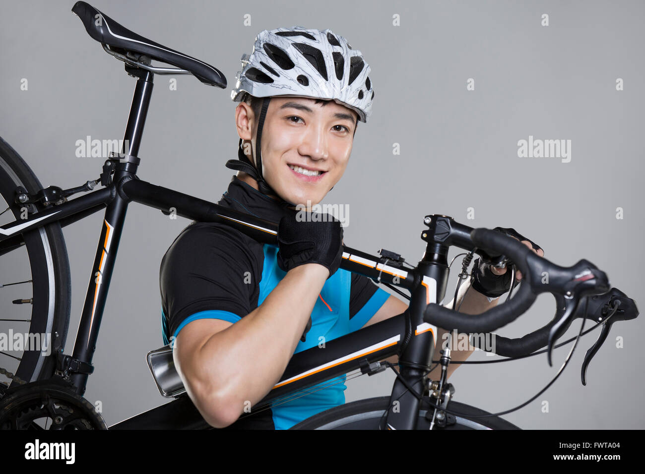 Young man carrying bicycle on shoulder Stock Photo - Alamy