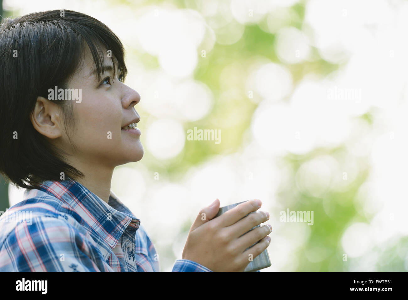 Young Japanese woman drinking coffee at a camp site Stock Photo - Alamy