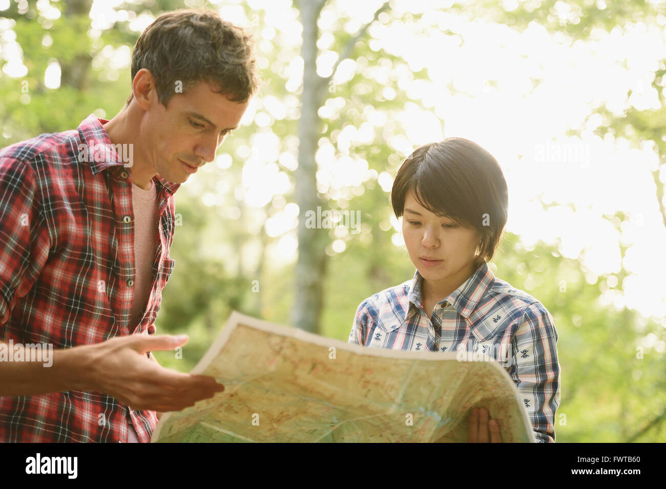 Friends checking map at a camp site Stock Photo - Alamy